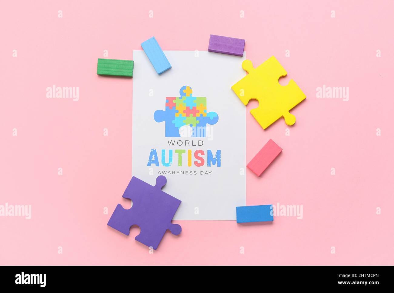 Paper sheet with text WORLD AUTISM AWARENESS DAY, puzzle pieces and ...