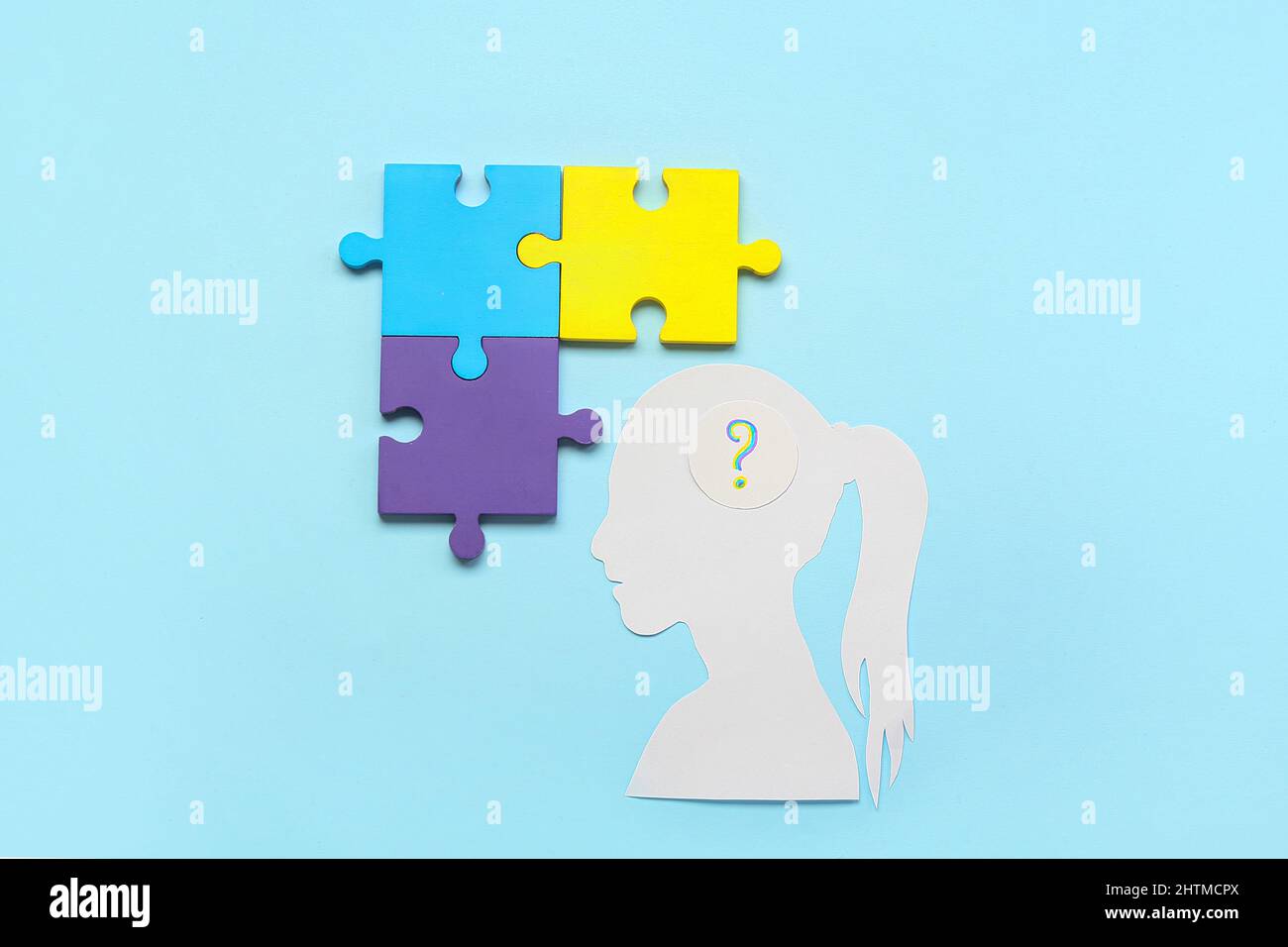 Paper female head with question mark and puzzle pieces on blue ...