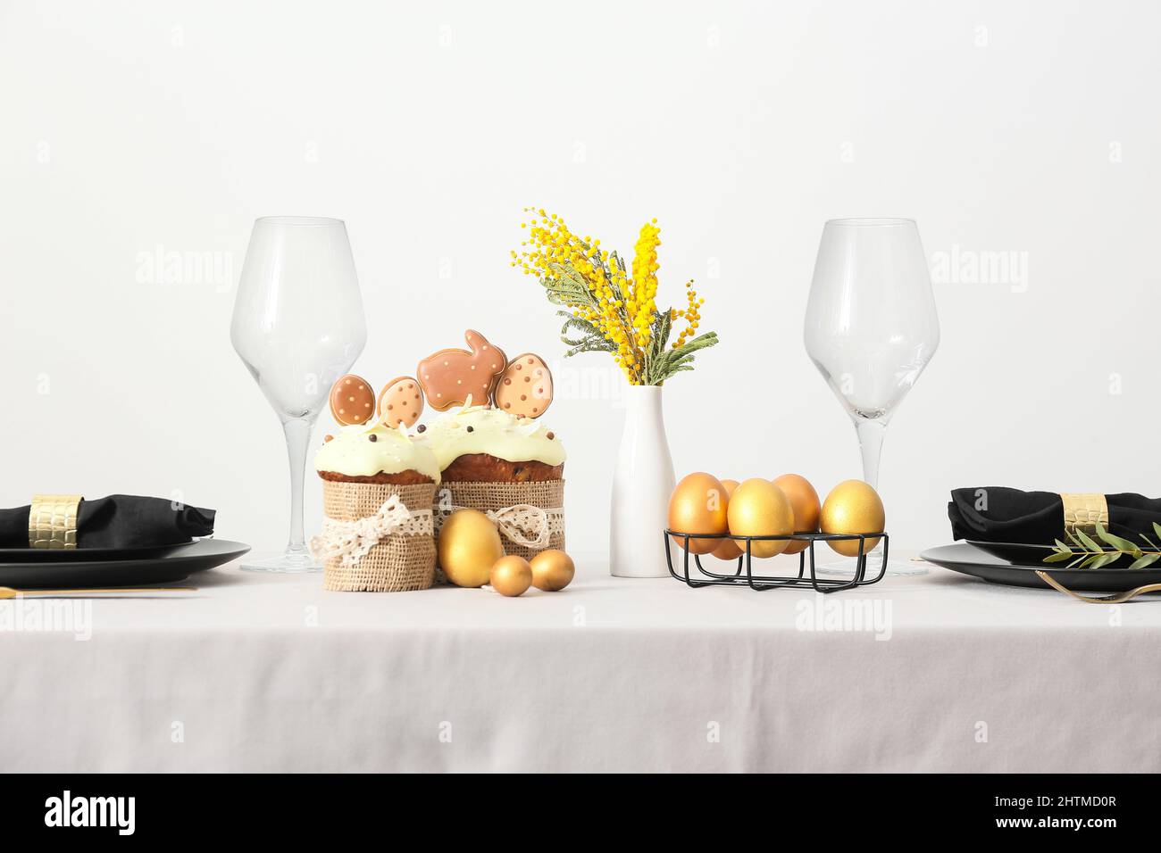 Beautiful Easter table setting with mimosa flowers near light wall ...