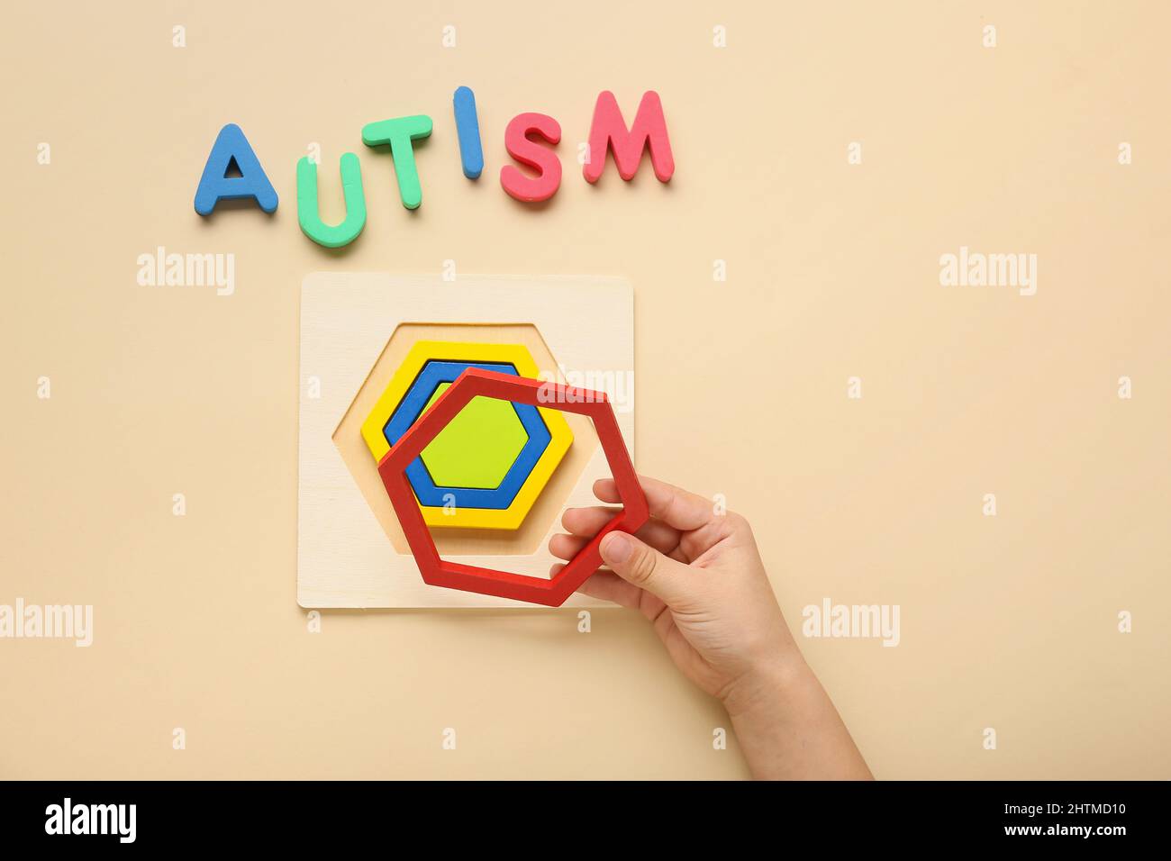 Child with toy and word AUTISM on beige background Stock Photo - Alamy