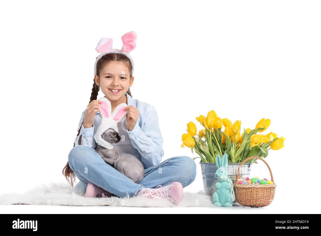 Little girl with Sphynx cat, Easter eggs, rabbit and tulips on white ...