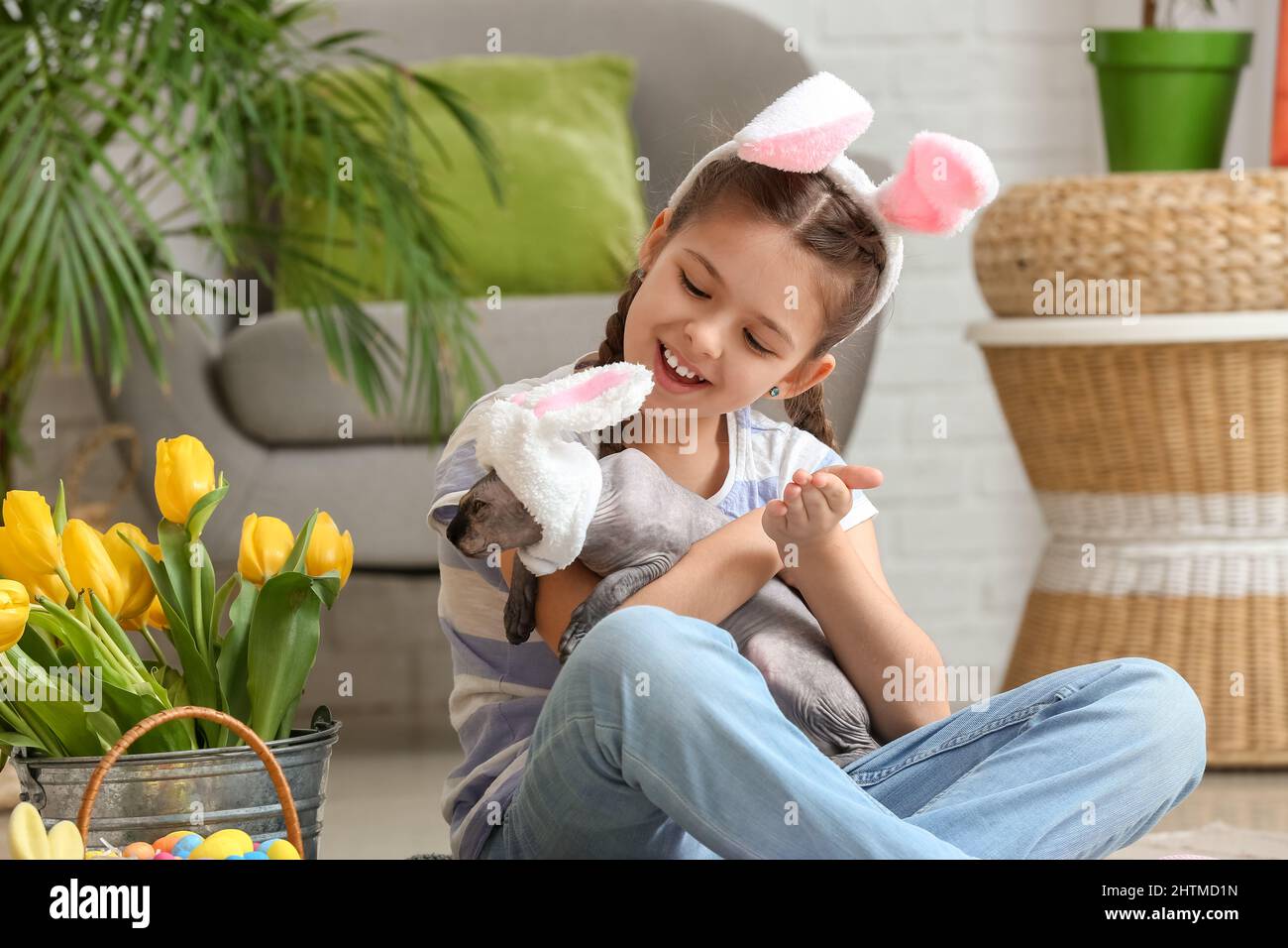 Little girl with Sphynx cat, Easter eggs and tulips at home Stock Photo ...