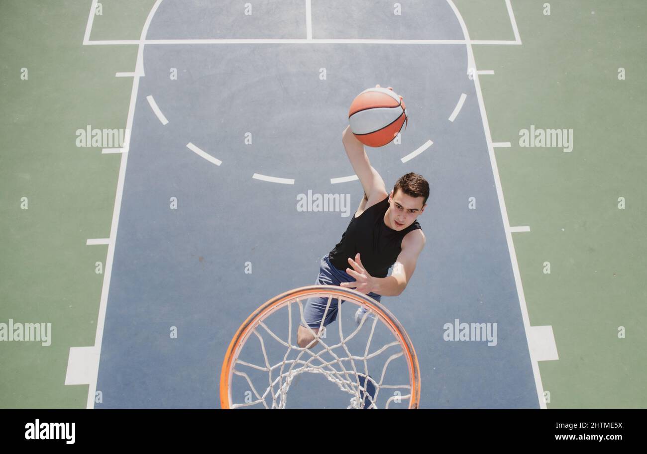 Angle view of man playing basketball, above hoop of man shooting ...