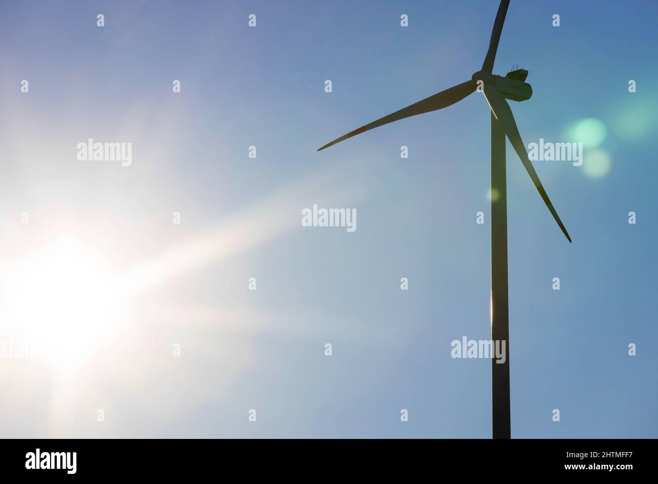 a sun ray and a wind turbine Stock Photo - Alamy