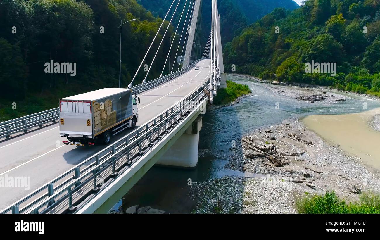 Truck crosses beautiful bridge in summer. Scene. Top view of truck ...