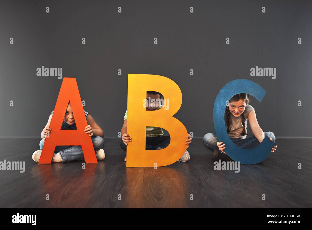 Children holding alphabet letters hi-res stock photography and images ...