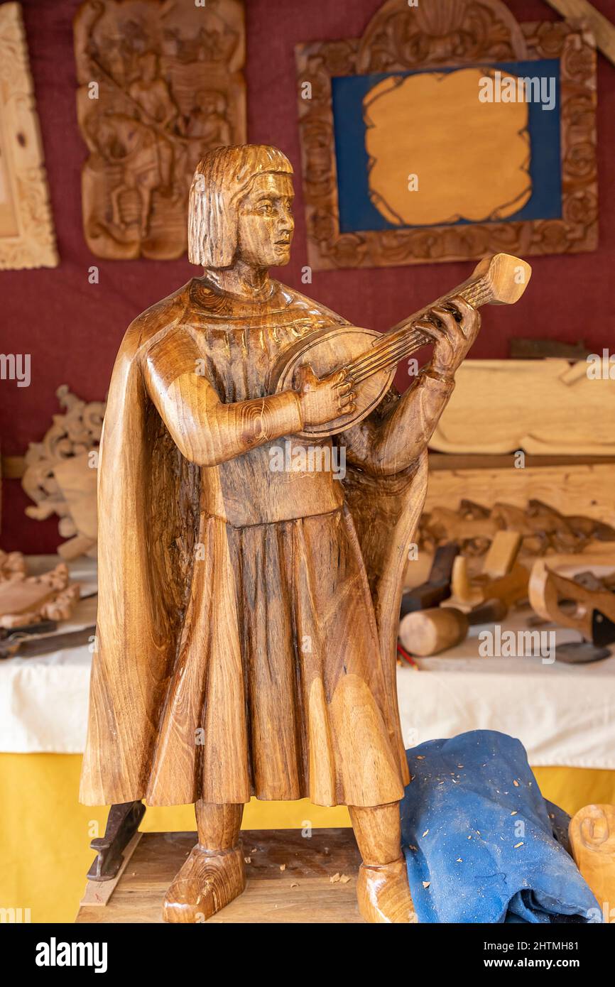 vertical view of a wood carving depicting a minstrel playing his lute ...