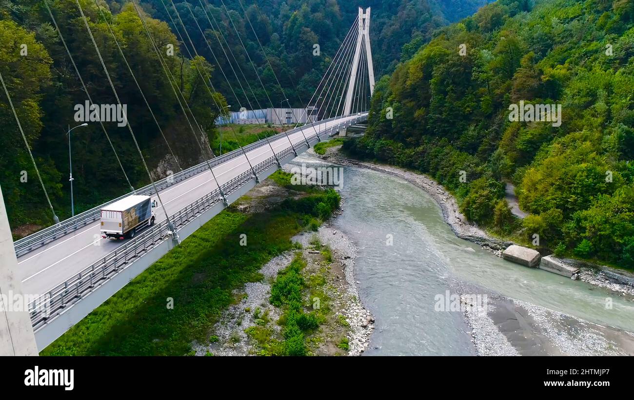 Truck crosses beautiful bridge in summer. Scene. Top view of truck ...