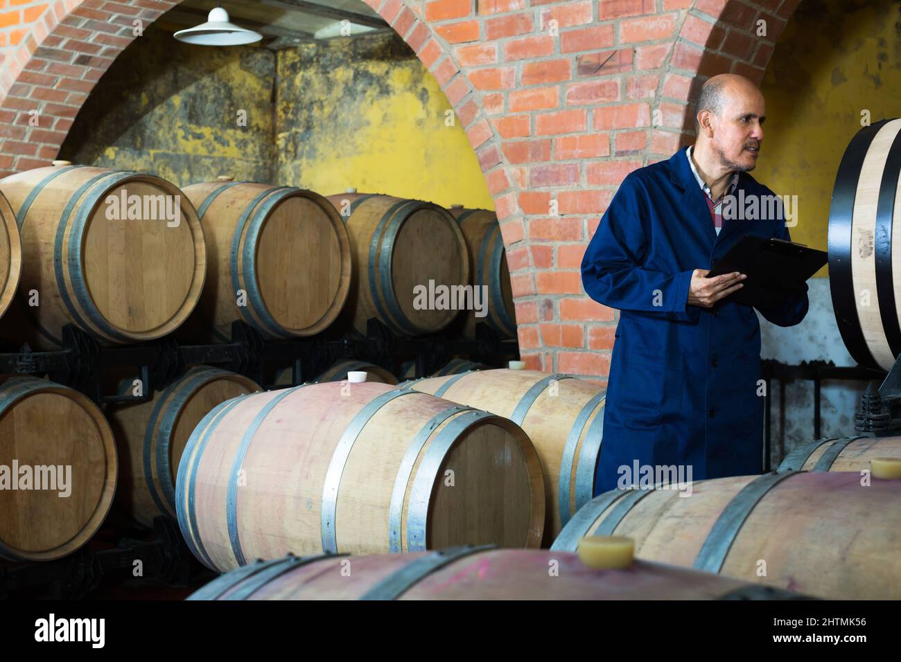 winery employee in cellar with woods Stock Photo - Alamy