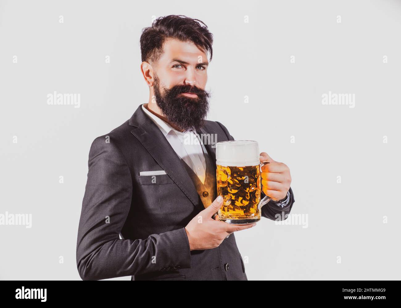 Serious man in classic suit drinking beer. Bearded guy in business ...