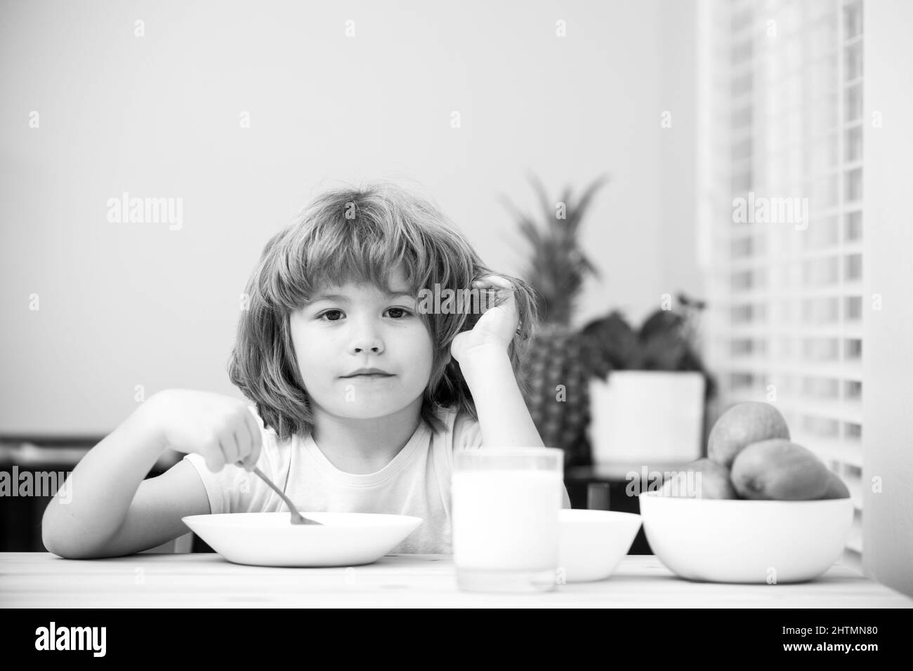 Portrait of cute child eating soup meal or breakfast having lunch by ...