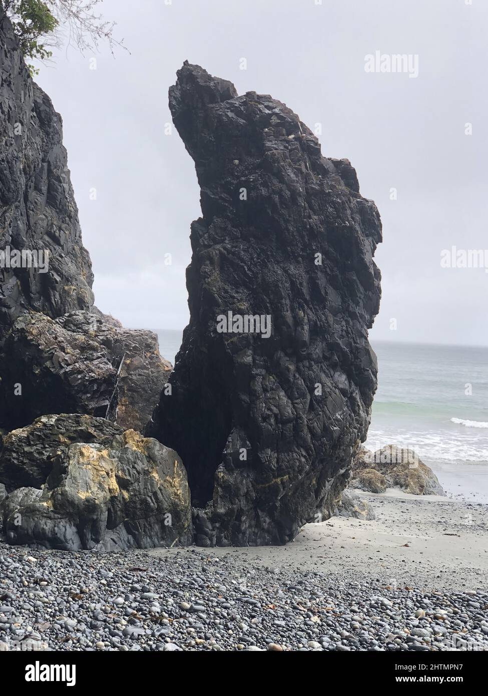 A big rock in a curved shape on a beach Stock Photo - Alamy