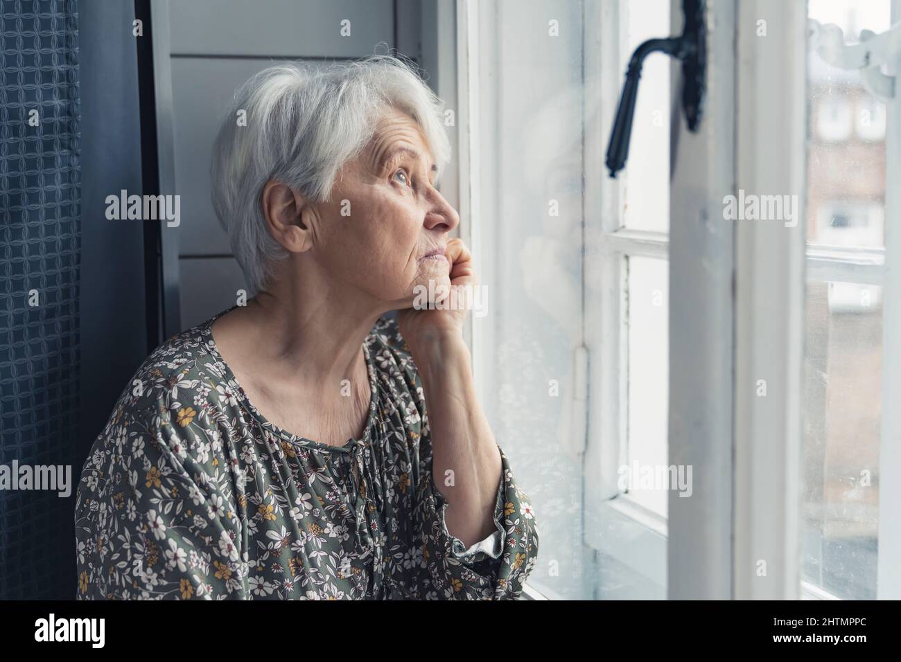 Elderly lady looking out window hi-res stock photography and images - Alamy