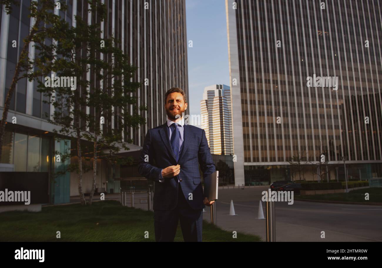 Handsome middle age business man in suit while standing mear office ...