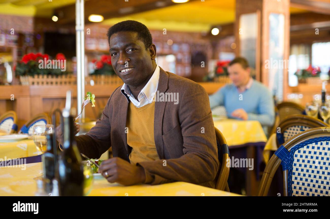African-american man eating in restaurant Stock Photo - Alamy