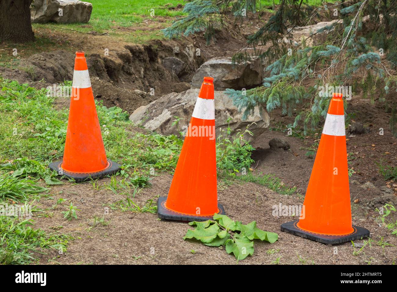 Fluorescent orange traffic cones at worksite in public landscaped ...