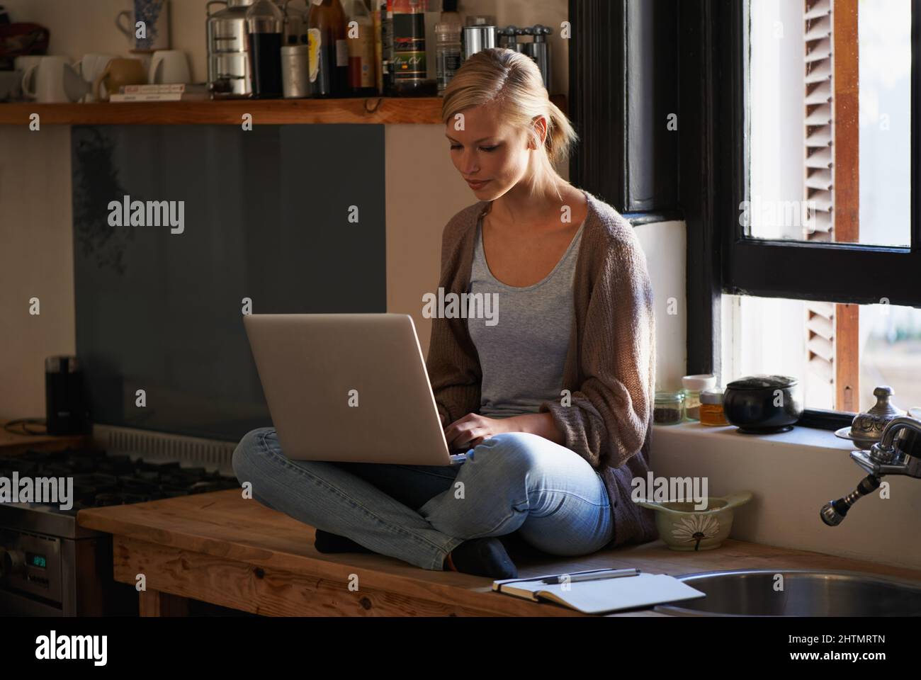 Finding the right recipe online. Shot of a young woman sitting on her ...