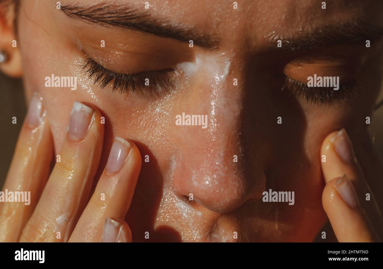 Acne protection. Girl washing face with cleancing products. Cosmetics ...