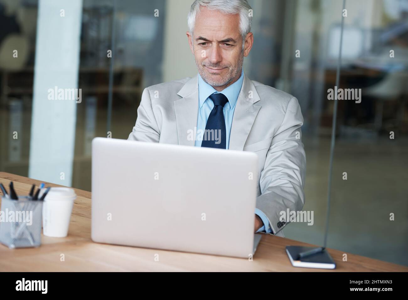 Getting down to business. A manager working on his laptop in the office ...