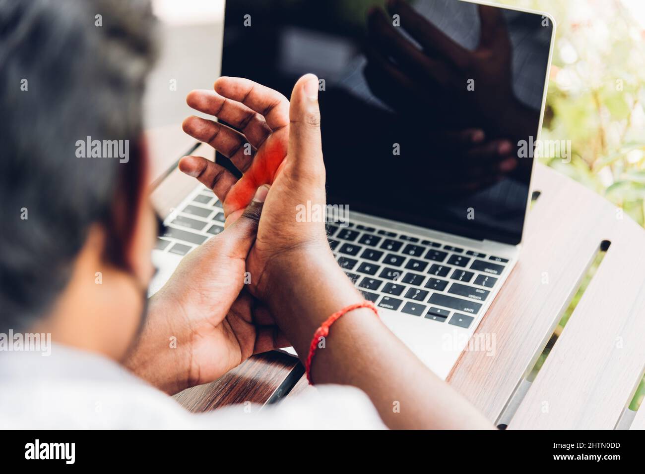 Closeup hands the Asian black man holding his wrist pain from using ...