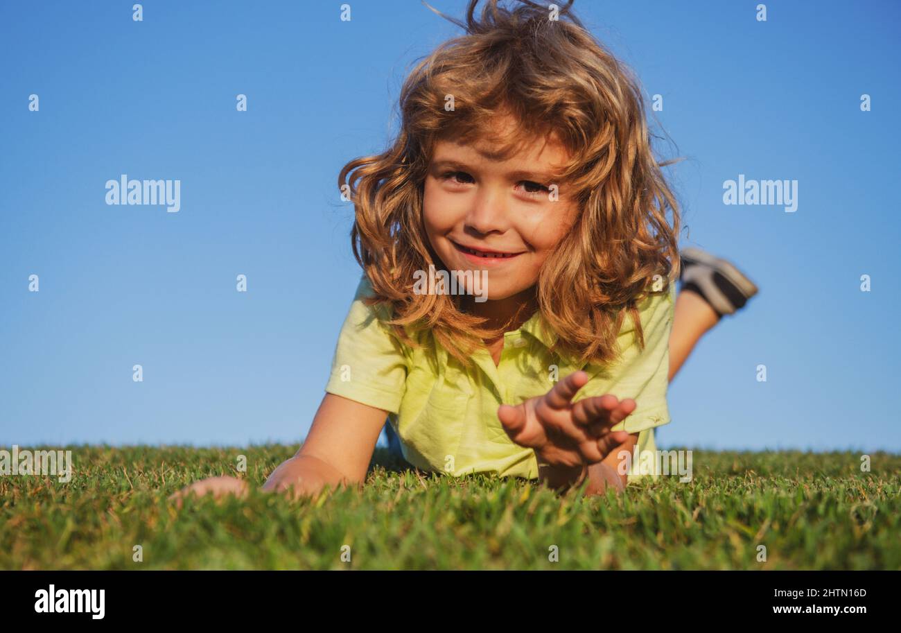 Portrait of a happy smiling child boy playing on grass field. Laughing ...