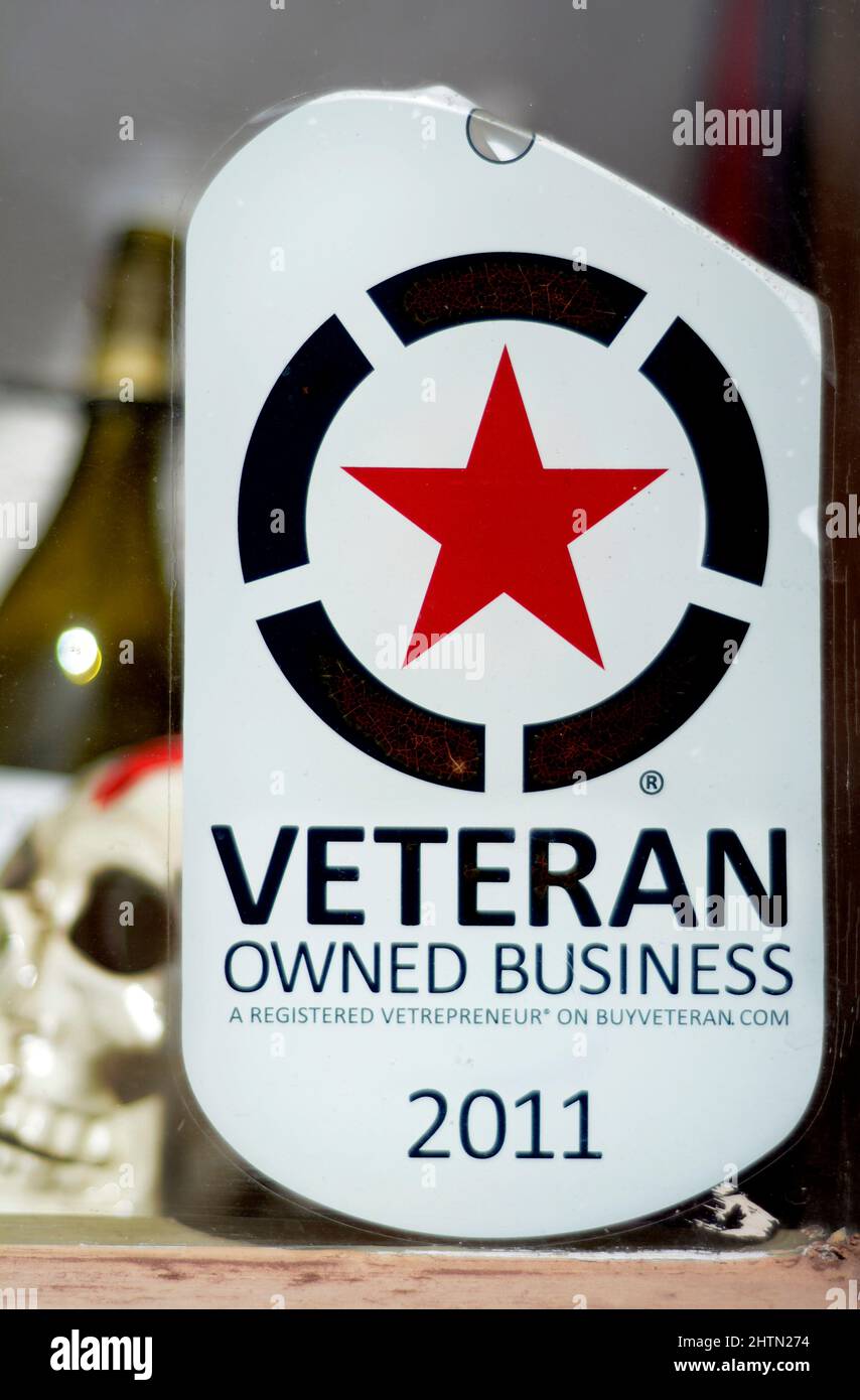 A sign in a store window identifies the business as owned by a US ...