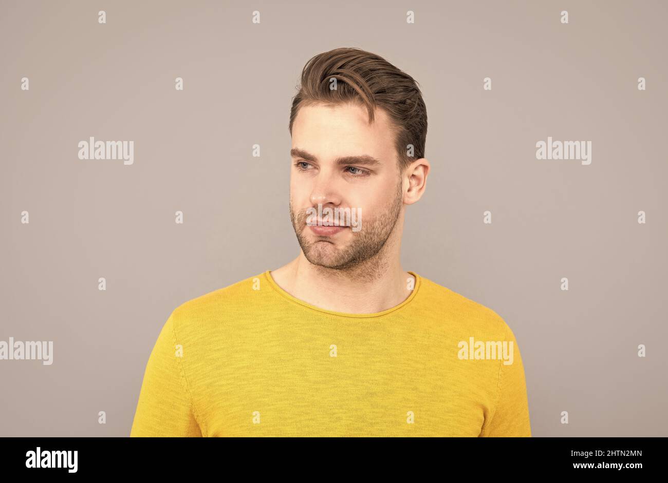 Good-looking young man portrait with unshaven face in yellow sweater ...