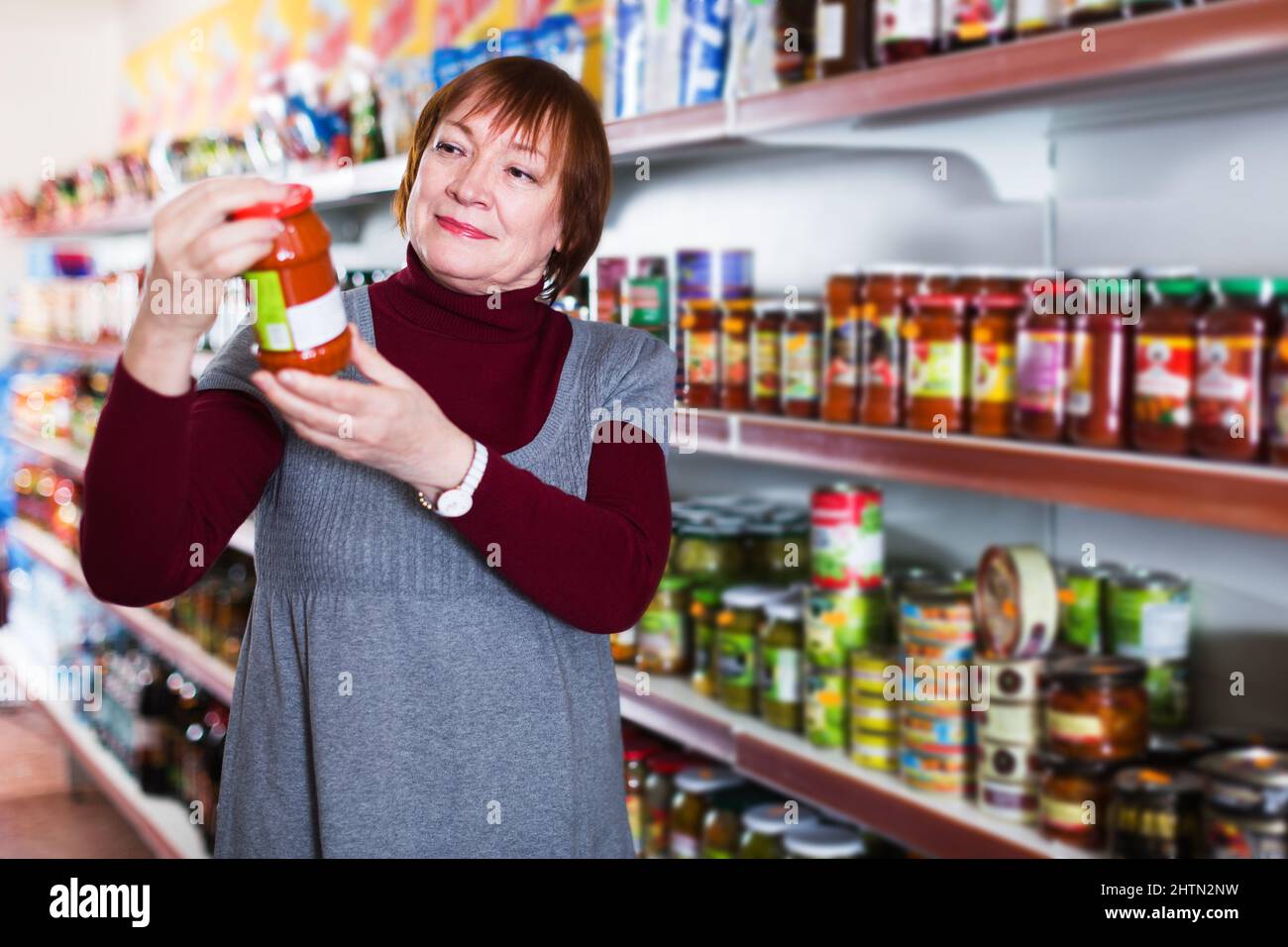 female consumer choosing tomato paste Stock Photo - Alamy