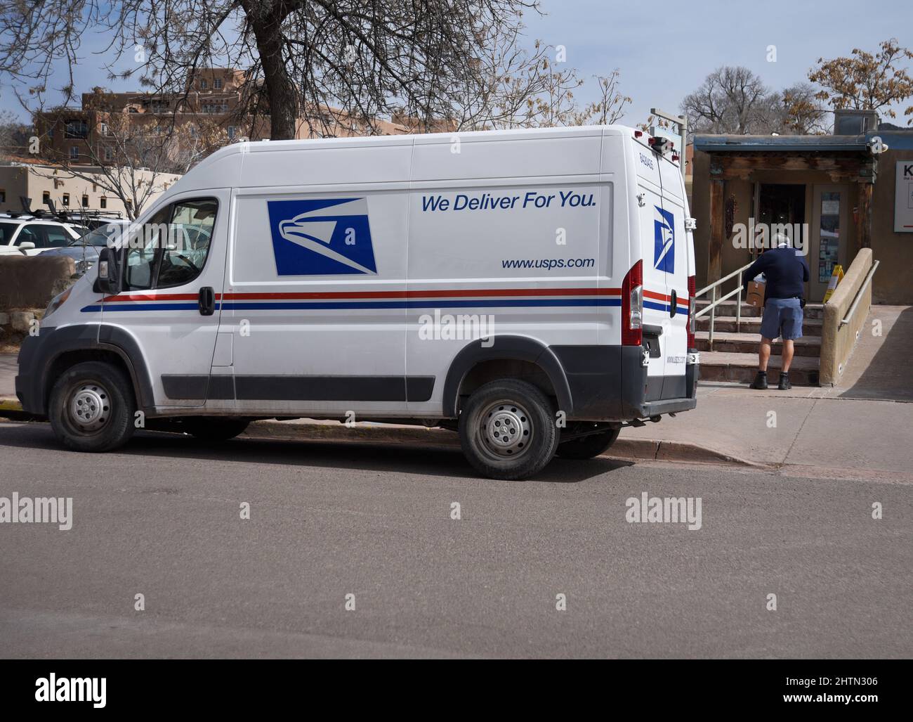 A US postman or mailman delivers a package to a business in Santa Fe ...