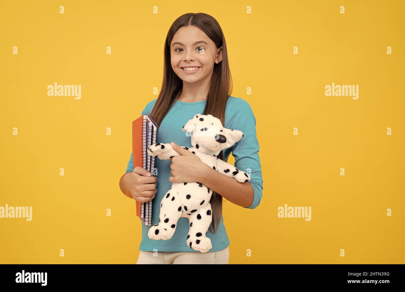 cheerful child girl hold notepad for homework and dog toy, childhood ...