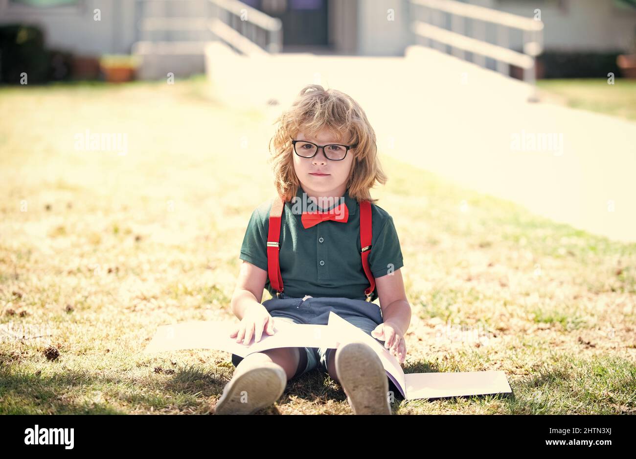 smart curious nerd in glasses reading book study with copybook outdoor ...