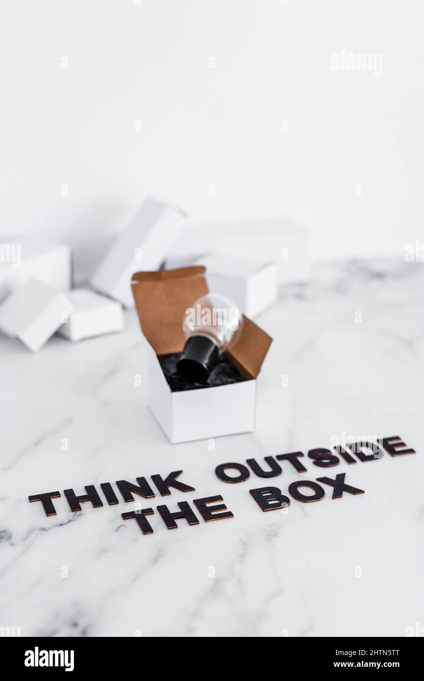 Think outside the box concept with idea lightbulb on top of white box ...
