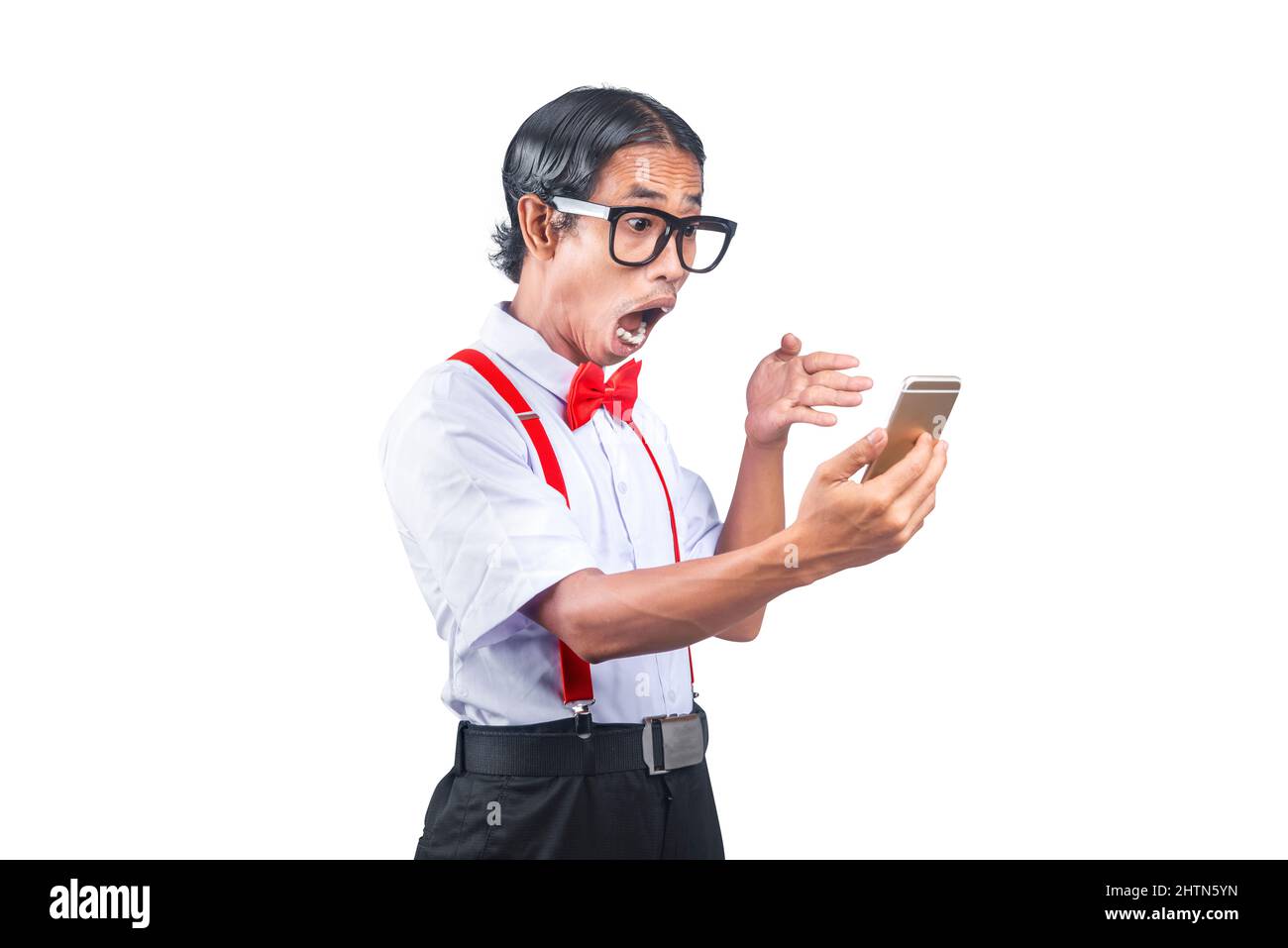 Asian nerd with an ugly face holding mobile phone with shocked ...