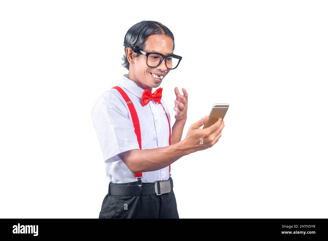 Asian nerd with an ugly face holding mobile phone isolated over white ...