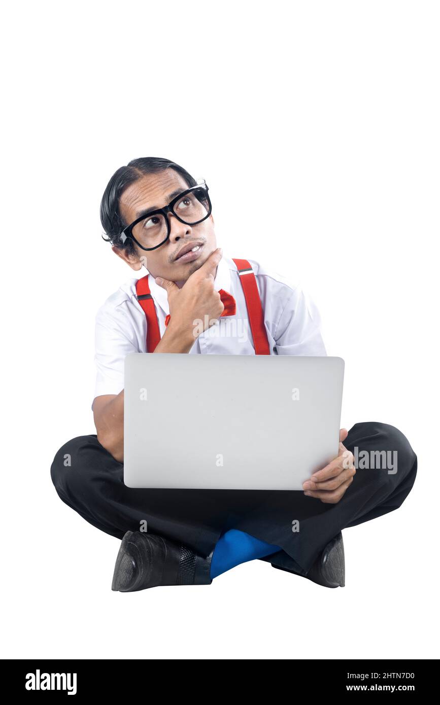 Asian nerd with ugly face sitting while using a laptop and thinking ...