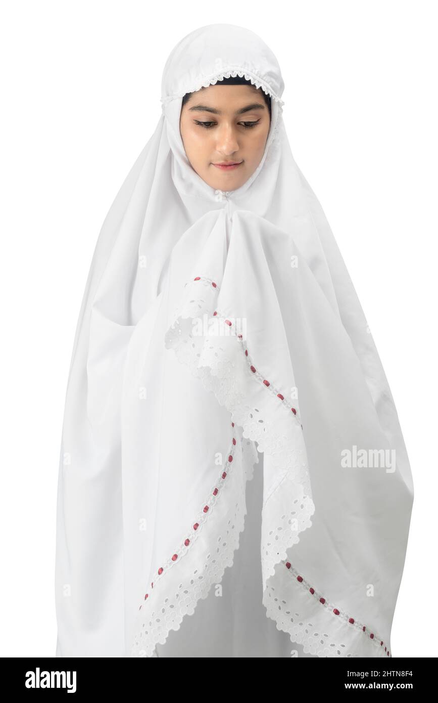 Asian Muslim woman in a veil standing while raised hands and praying ...