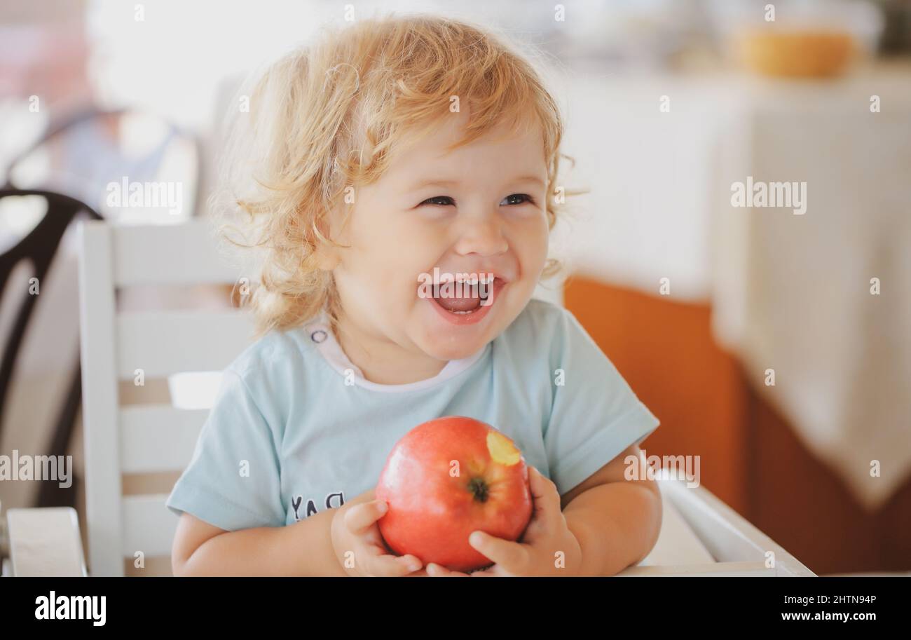 Laughing cute child eating apple. Cute baby eat apples. Portrait of ...