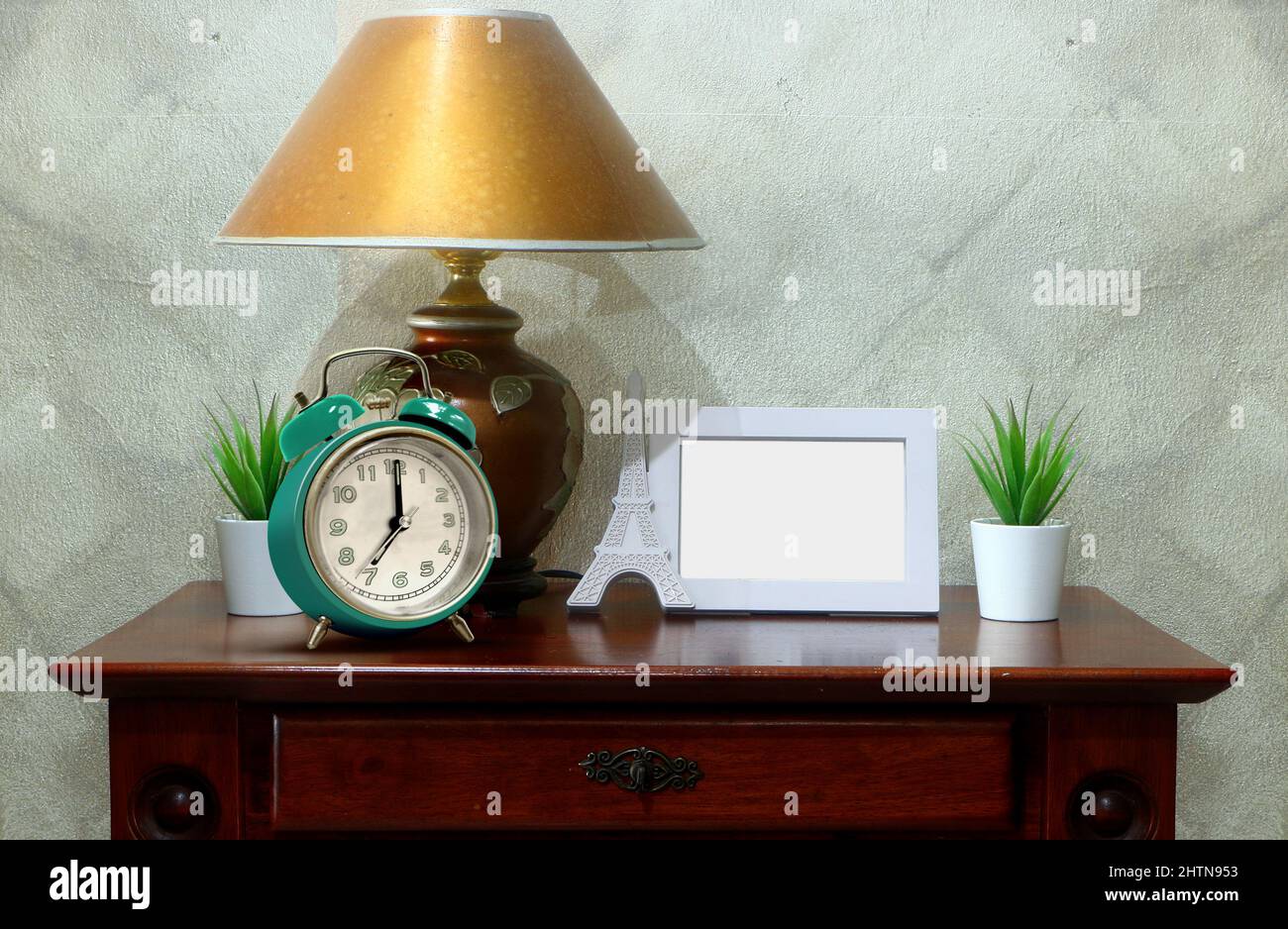side table with empty picture frame and alarm clock Stock Photo - Alamy