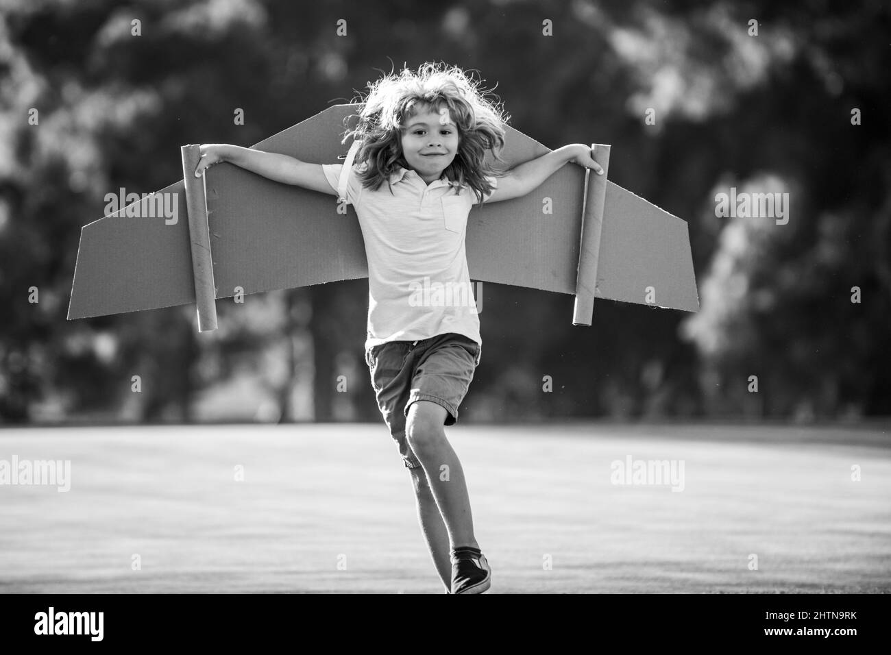 Kids fly. Funny child boy pilot flying with toy cardboard airplane ...