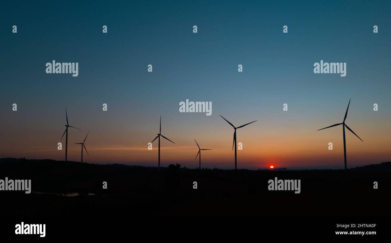wind turbine field at beautiful sunset sky background. renewable energy ...