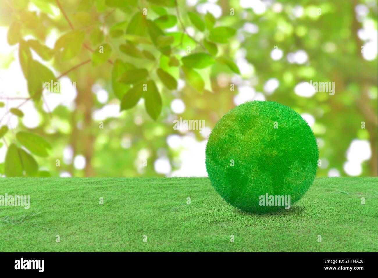 green grass globe earth on meadow over blur nature background. World ...