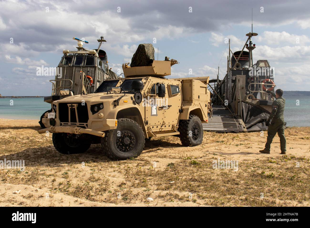 A U.S. Navy Sailor with Naval Beach Unit 7 ground guides a joint light ...