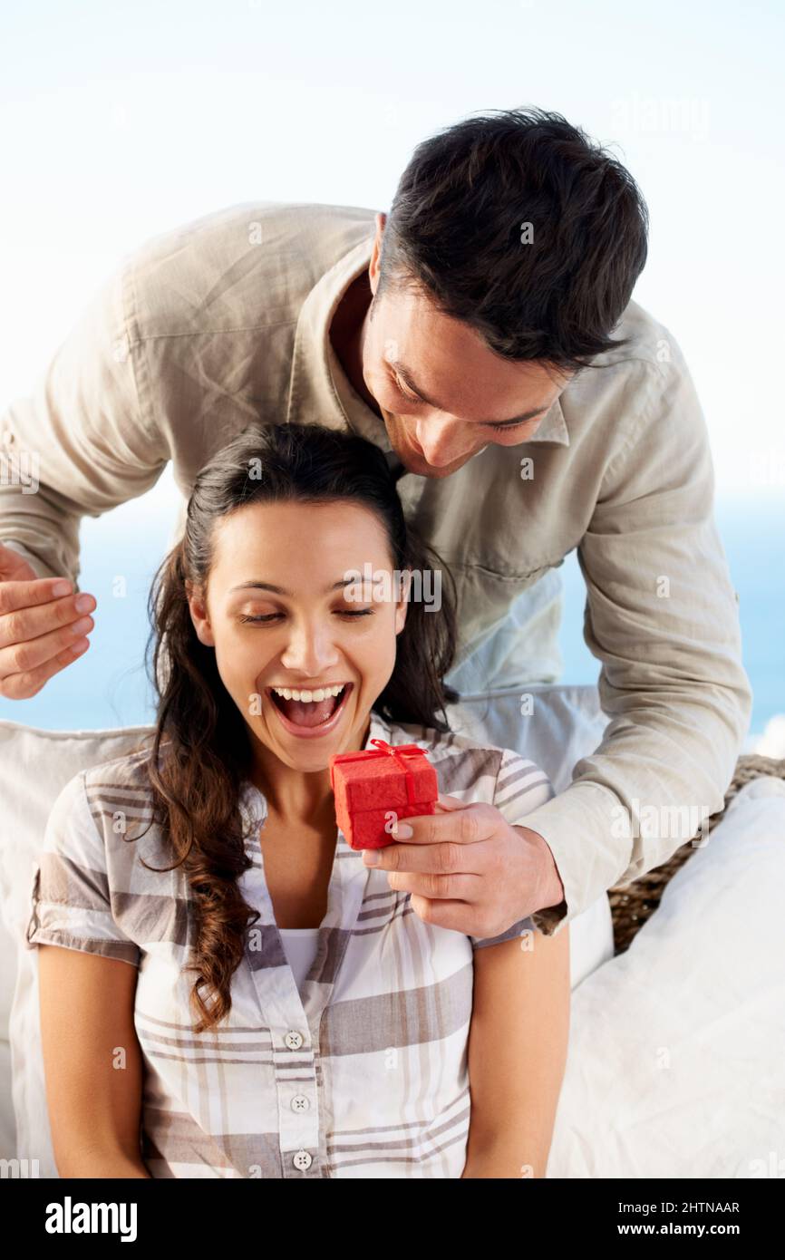Surprise proposal. A young man giving a ring box to his girlfriend ...