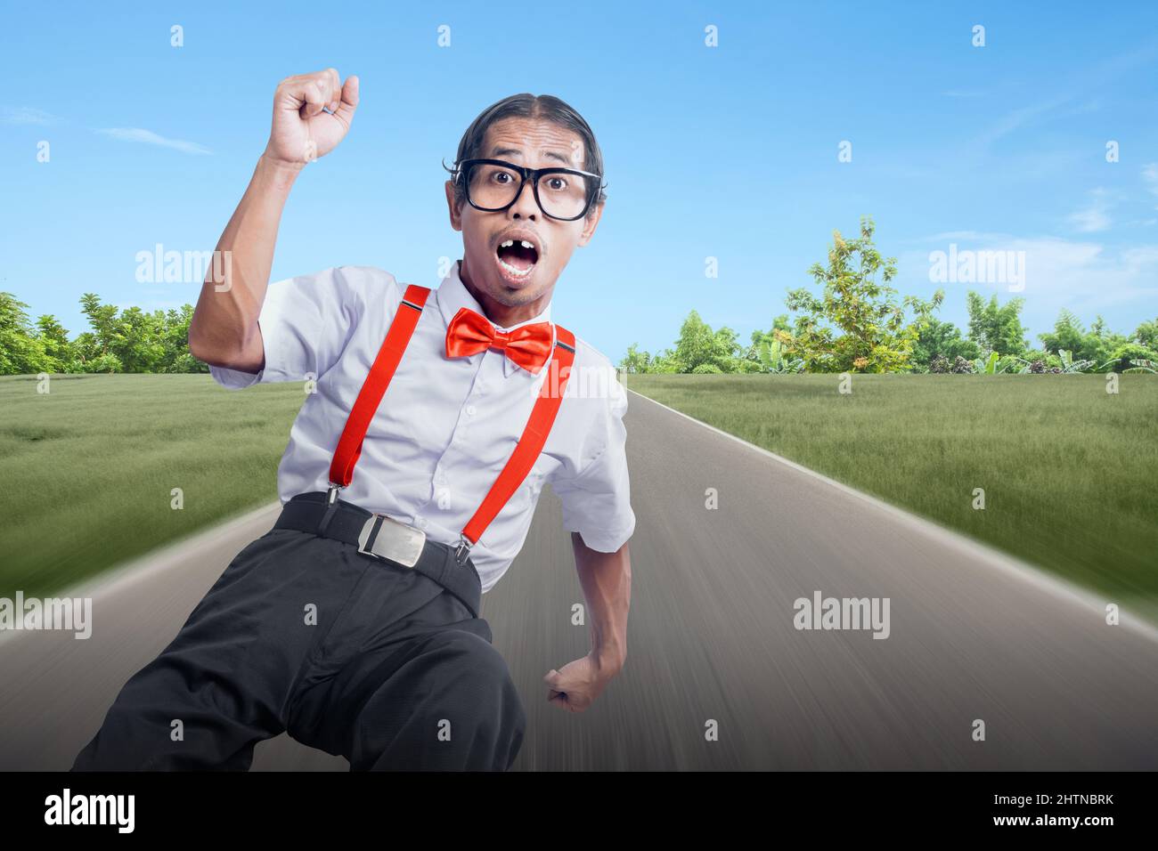 Asian nerd with ugly face running on the street with blue sky ...