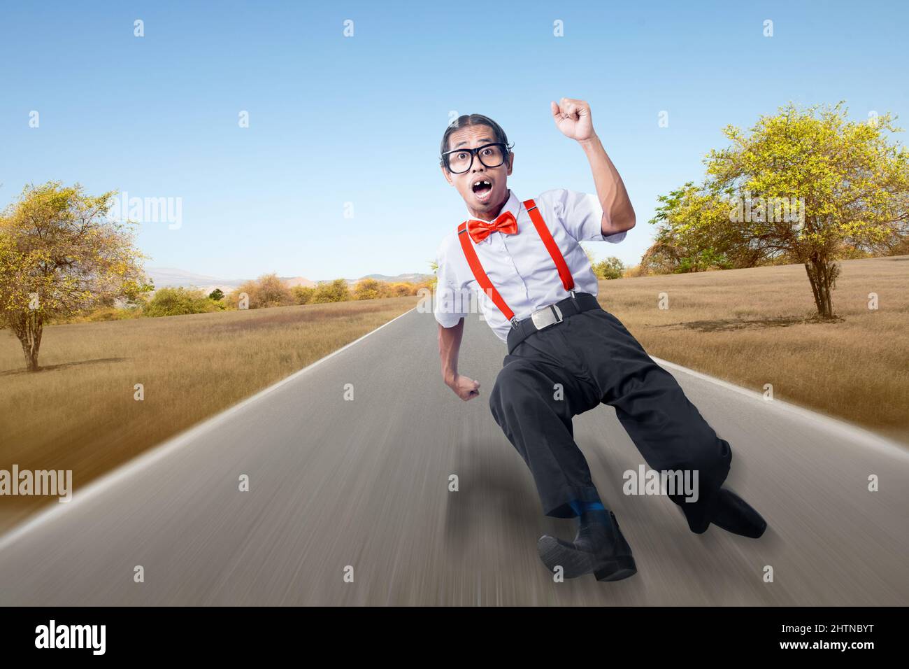 Asian nerd with ugly face running on the street with blue sky ...