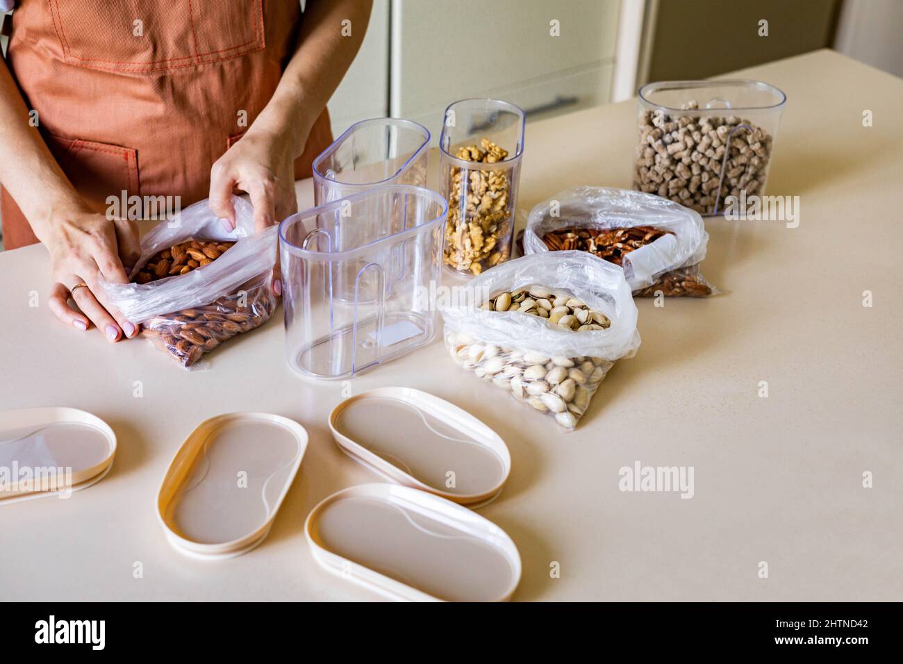 Closeup housewife hands placing nuts plastic package into container box ...