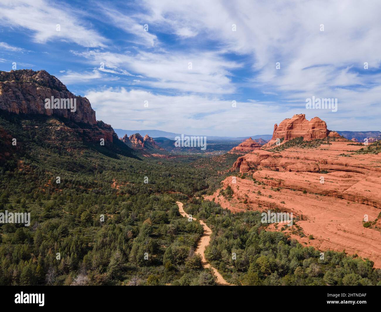 Dirt road going through desert shrubbery with mountains and rock ...