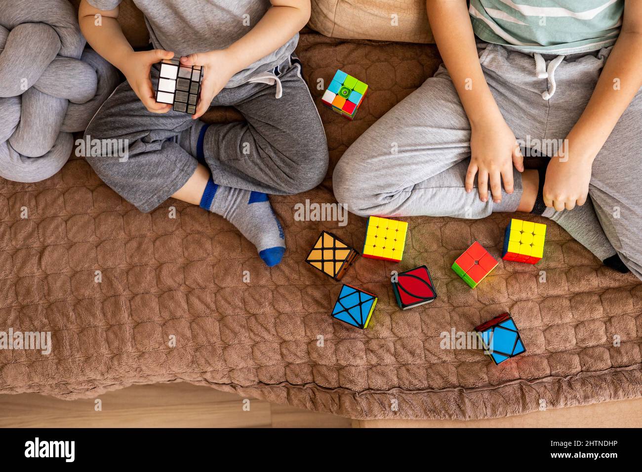 Two male kids brothers assembling Rubik's cube thinking solving logic ...