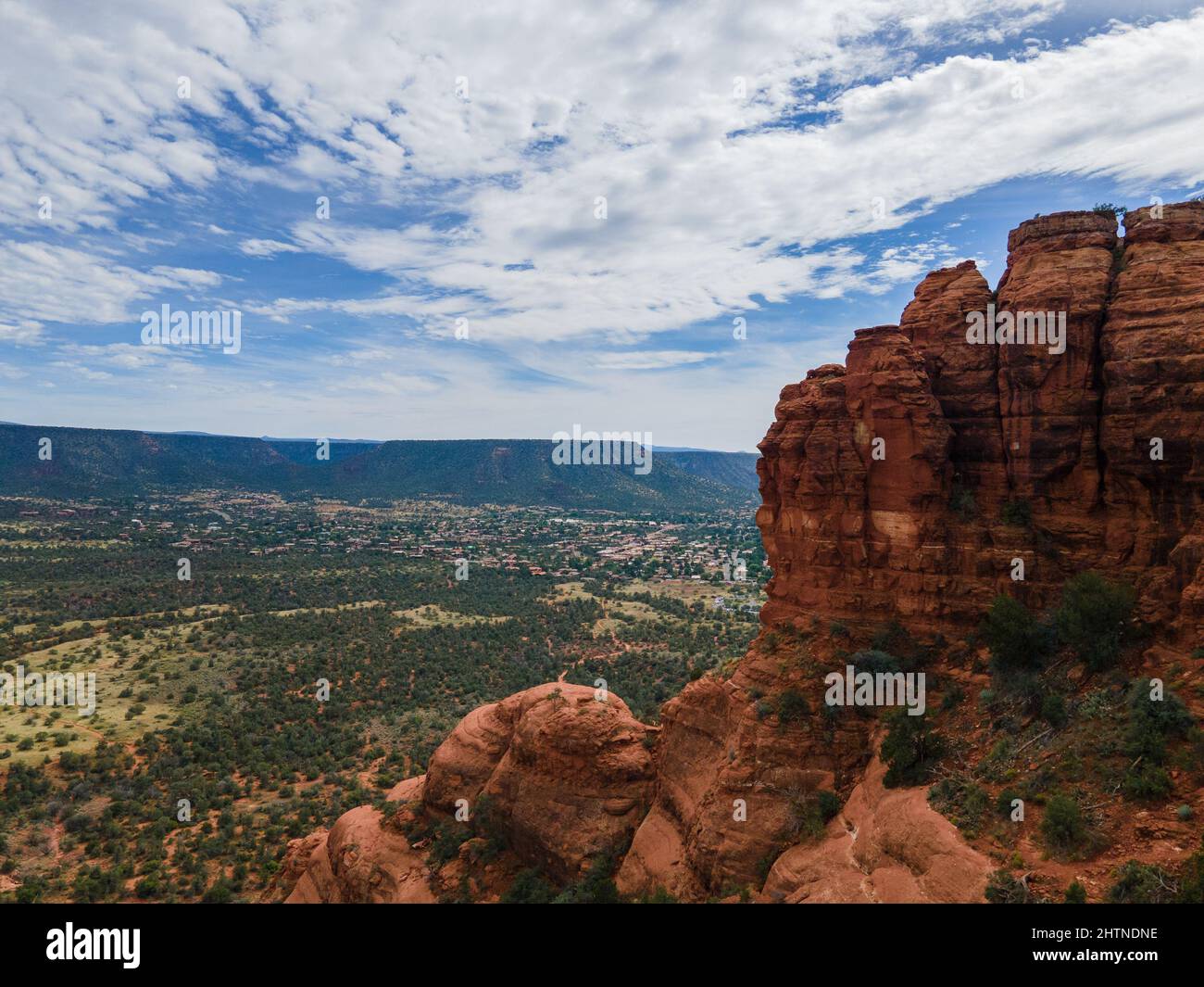Birds eye view of a huge rock formation with a valley and town in the ...