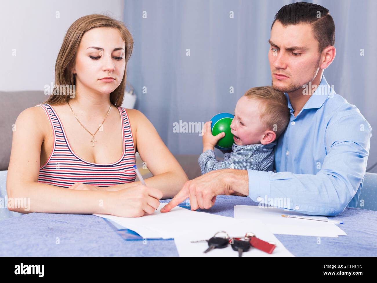 Sad woman with crying boy signing documents Stock Photo - Alamy
